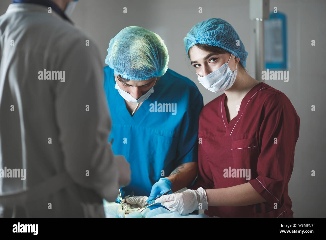 Portrait of surgeons at work, operating in uniform, looking at camera ...