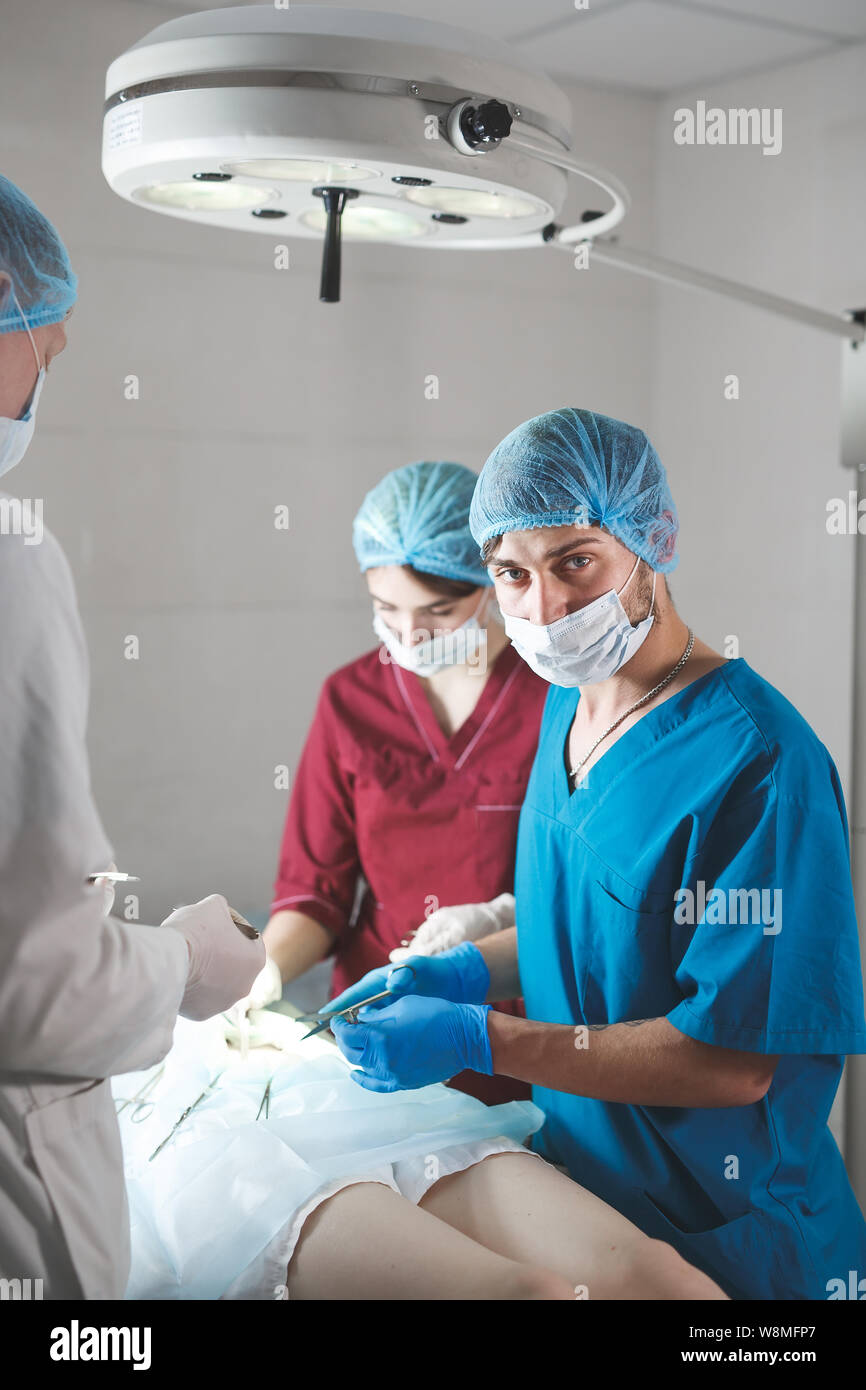 Portrait of surgeons at work, operating in uniform, looking at camera ...
