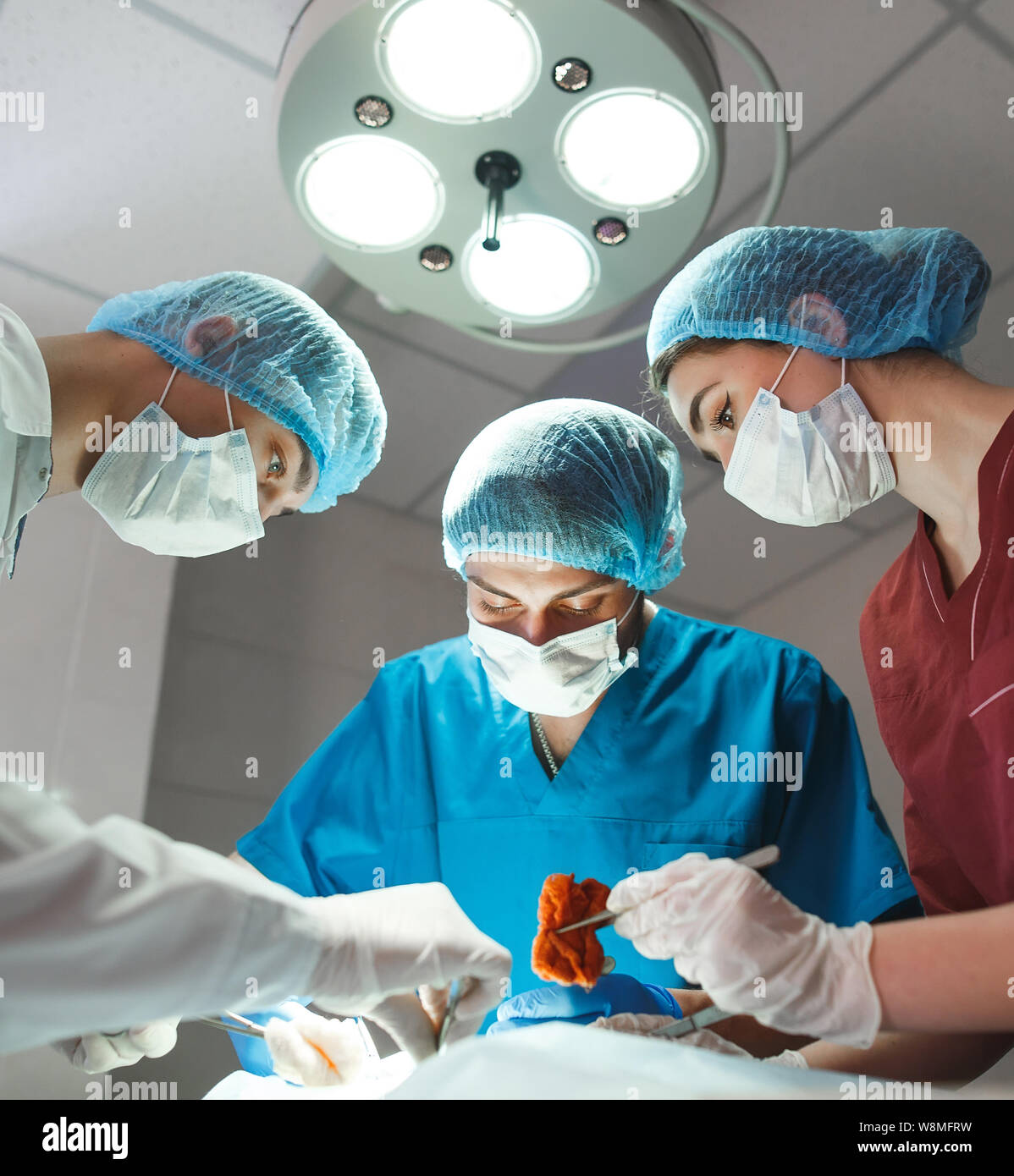 Group of surgeons at work operating in surgical theatre. Resuscitation ...