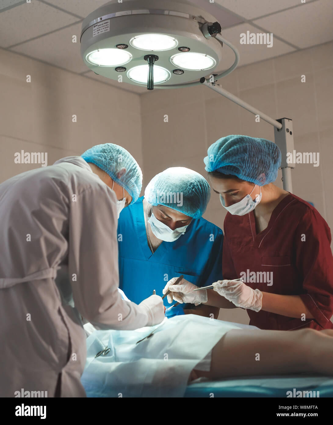 Group of surgeons at work operating in surgical theatre. Resuscitation ...