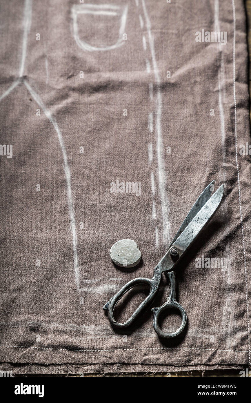 Tailor draft trousers on the material in tailoring workshop Stock Photo ...