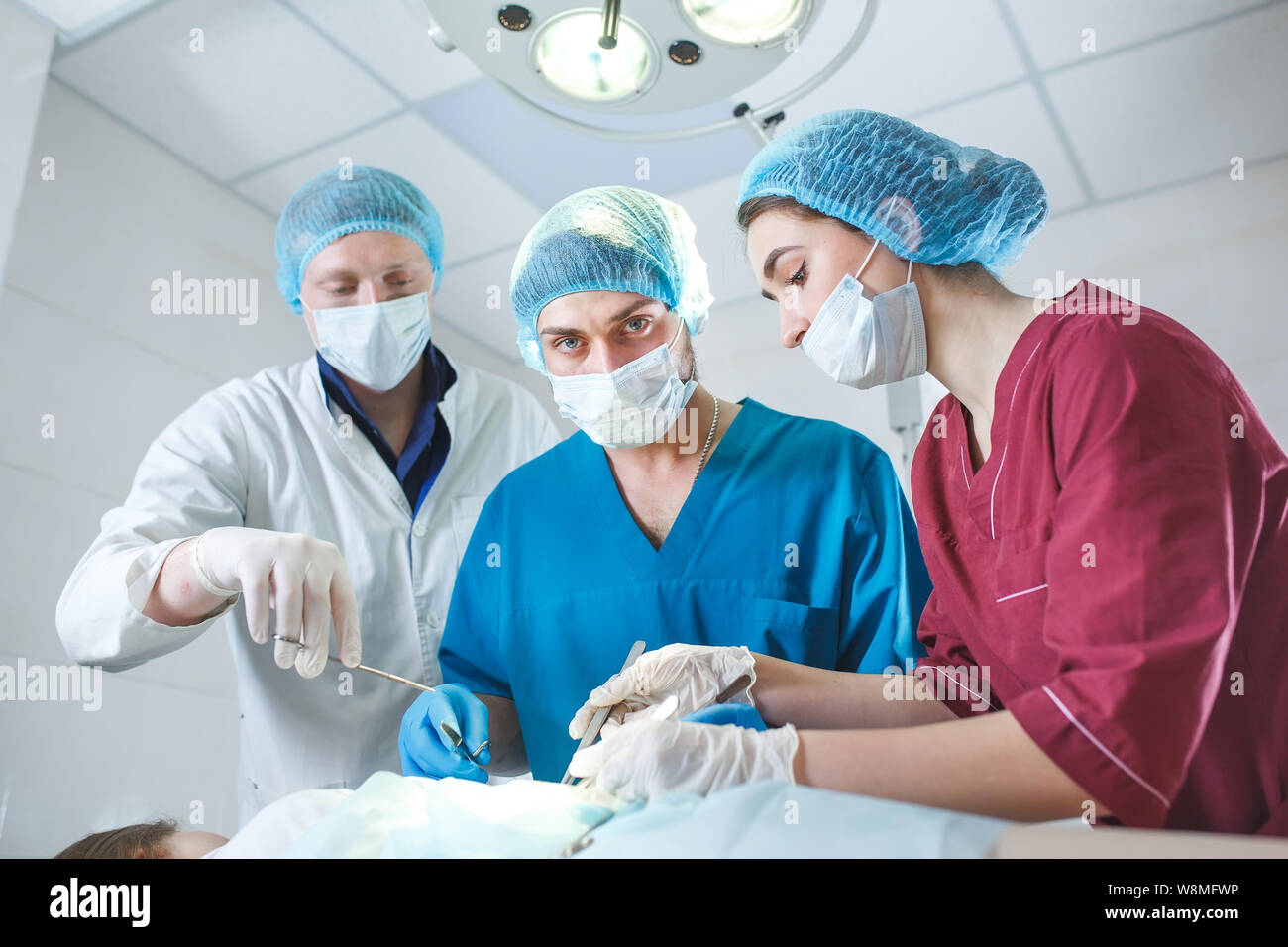 Group of surgeons at work operating in surgical theatre. Resuscitation ...
