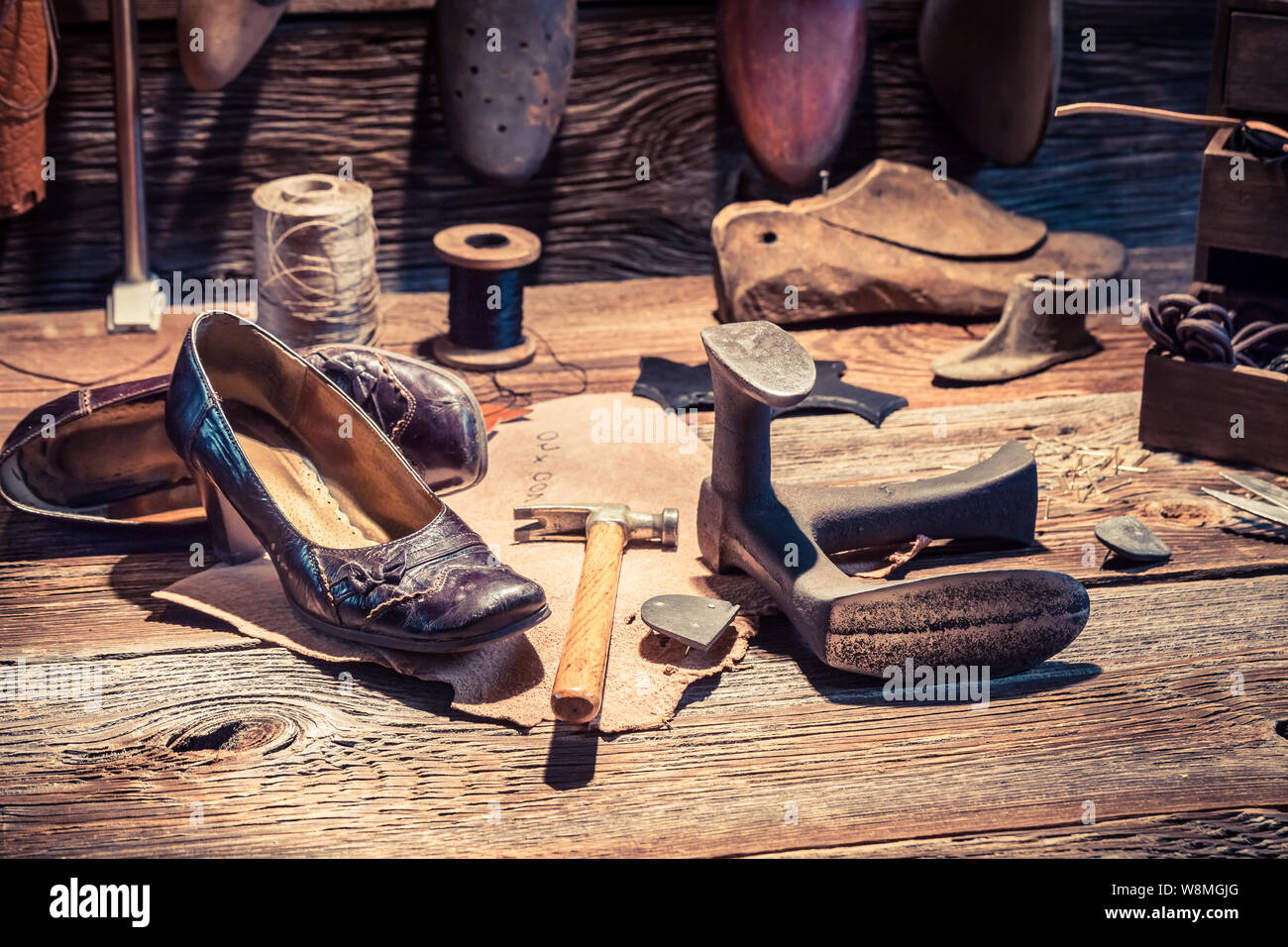 Rustic cobbler workshop with shoes, laces and tools Stock Photo - Alamy
