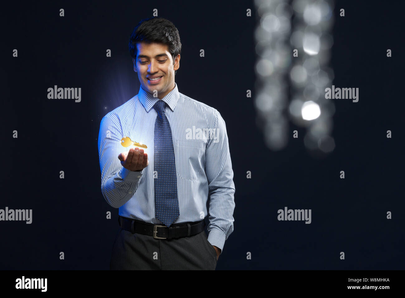 Businessman holding a glowing key Stock Photo - Alamy