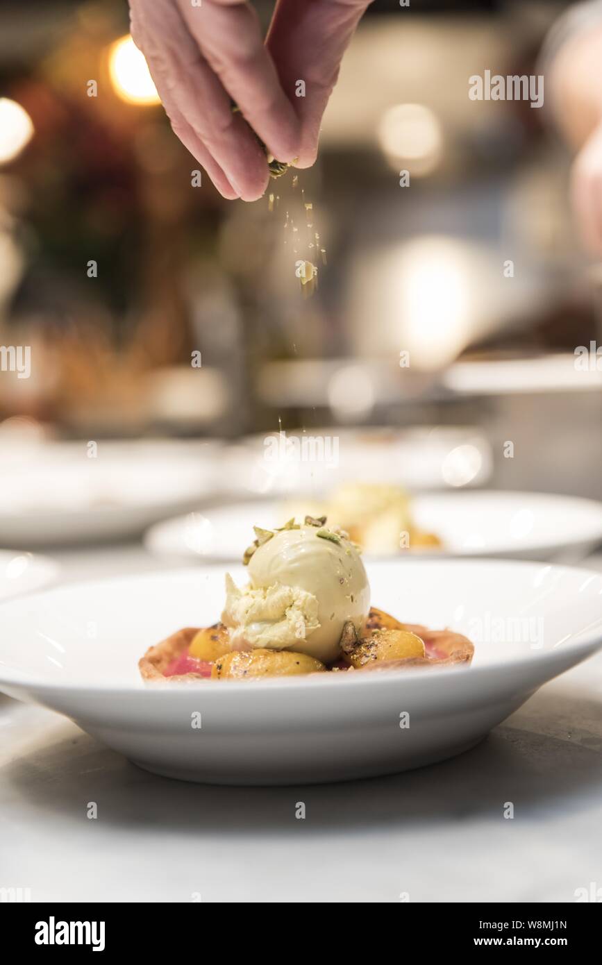 Chef's hand pouring ingredients onto a french dish Stock Photo - Alamy