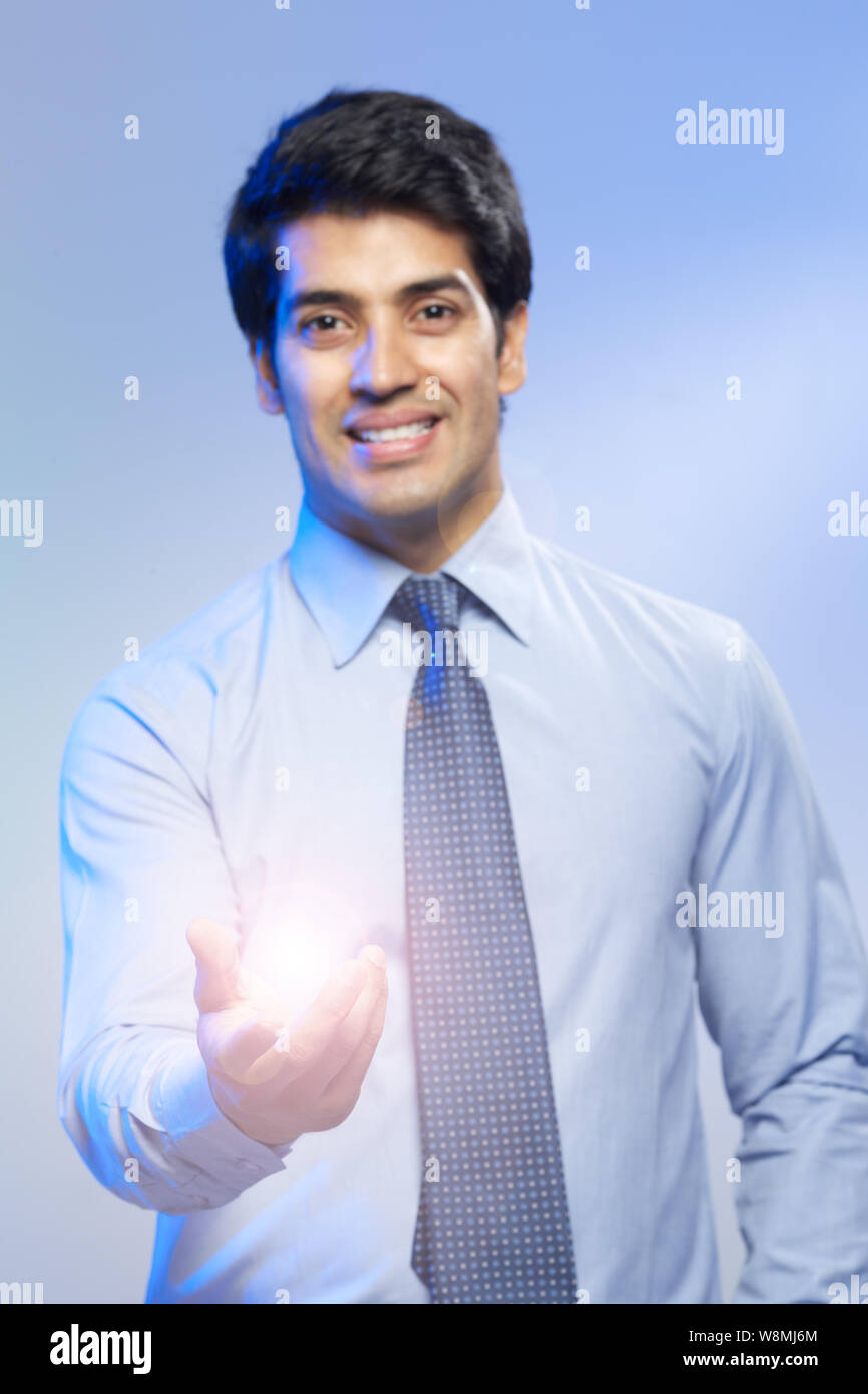 Businessman holding a ball of light Stock Photo - Alamy