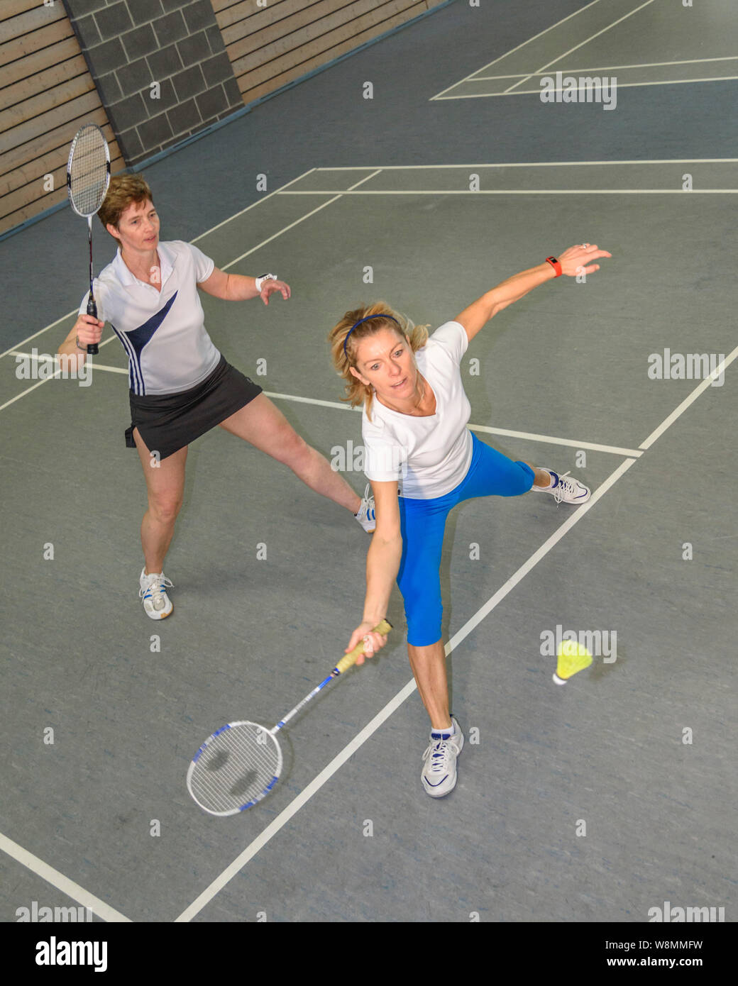 Badminton game scene in sports hall, a lot of effort and commitment ...