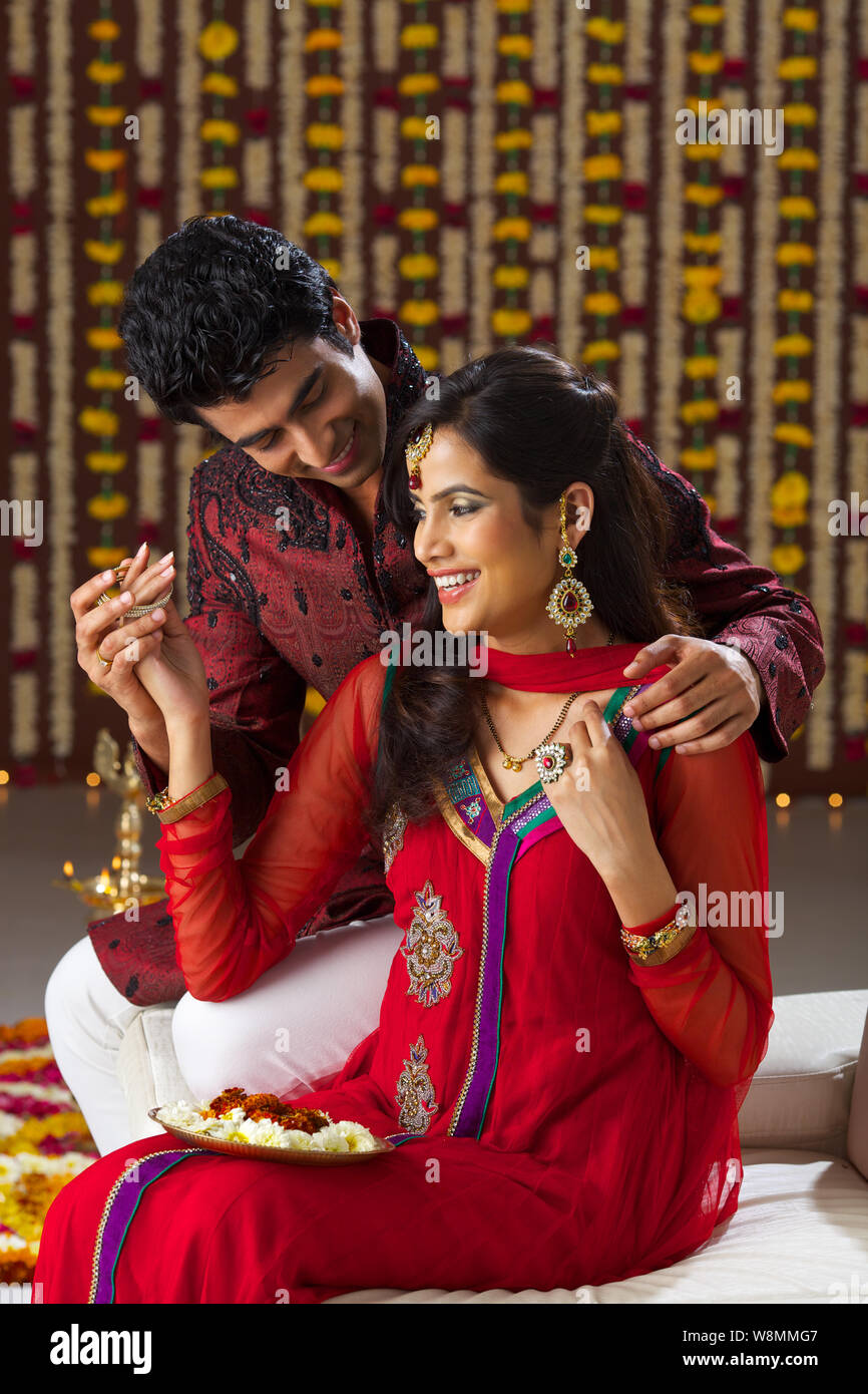 Young man putting on bangles in wife's hands Stock Photo - Alamy