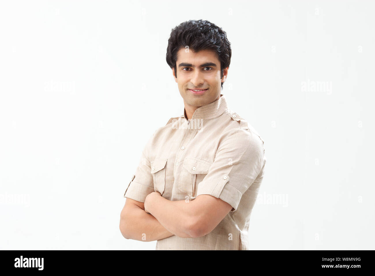 Young man smiling with his arms crossed Stock Photo - Alamy