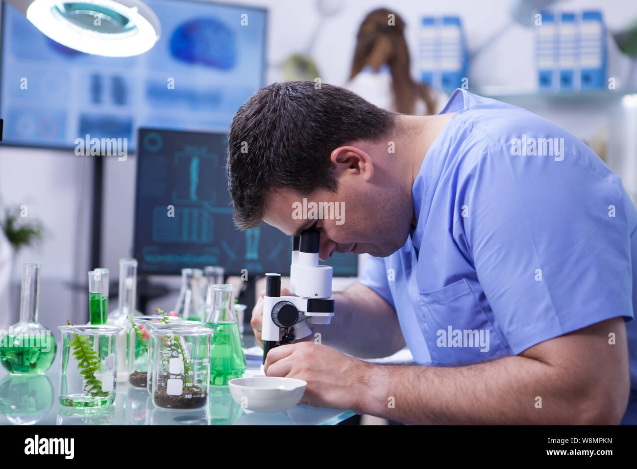 Caucasian scientist man in a biotechnology lab Looking through ...