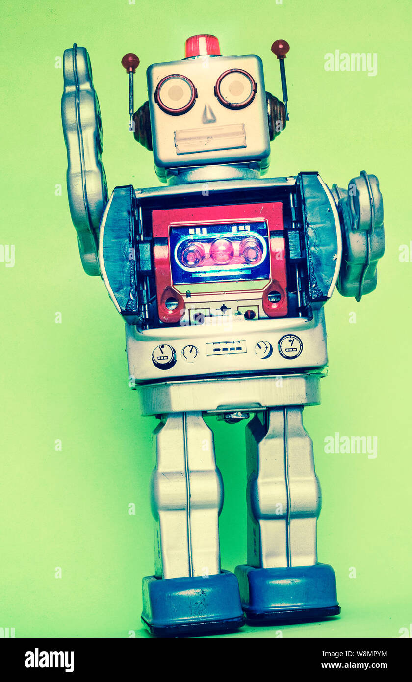 waving retro robot with a green background toned image Stock Photo - Alamy