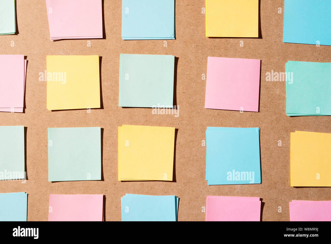 Multi colored notepads laying on a wooden plank board surface with copy ...