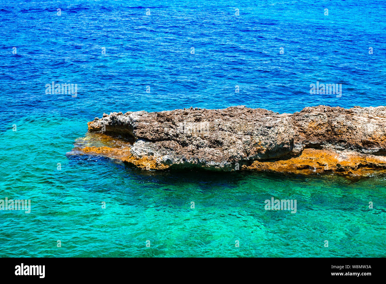 a rock in azure water Stock Photo - Alamy