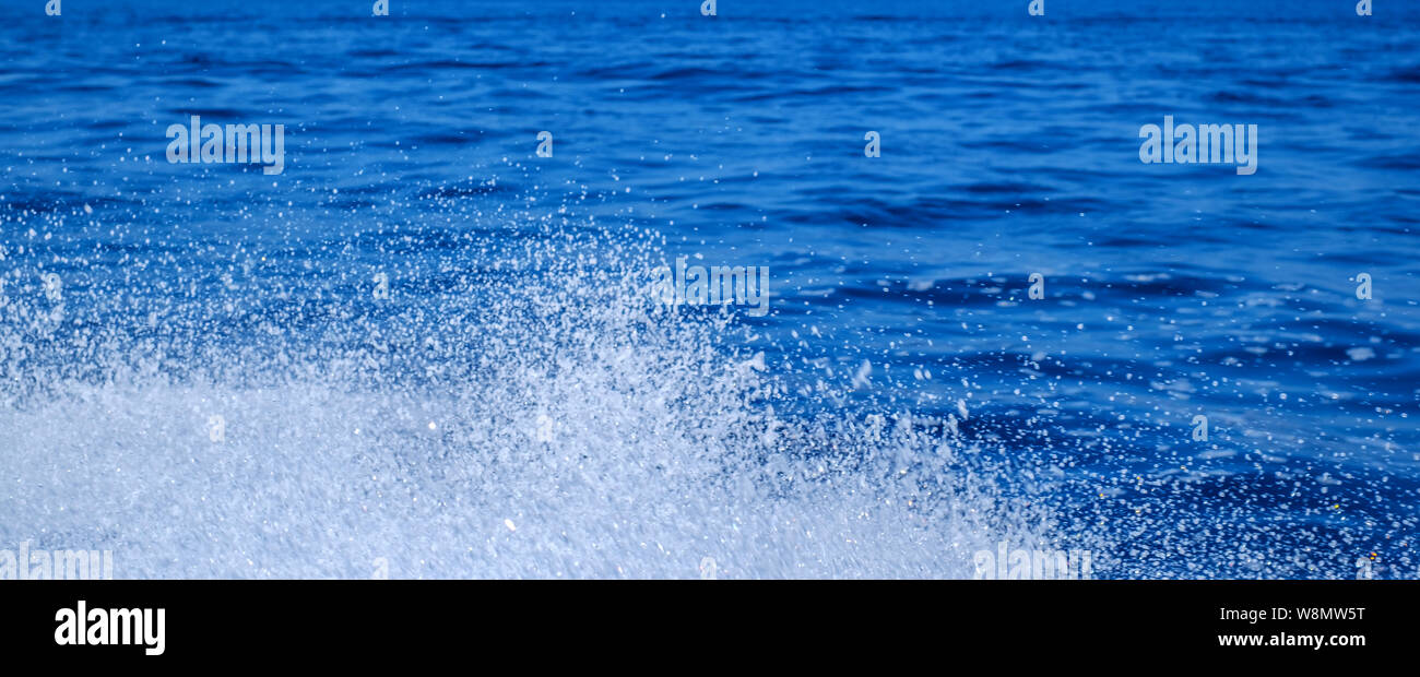 Blue ocean sea water wave with fast yacht boat wake foam of prop wash ...