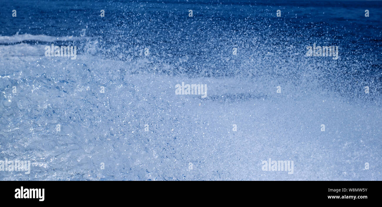 Blue ocean sea water wave with fast yacht boat wake foam of prop wash ...