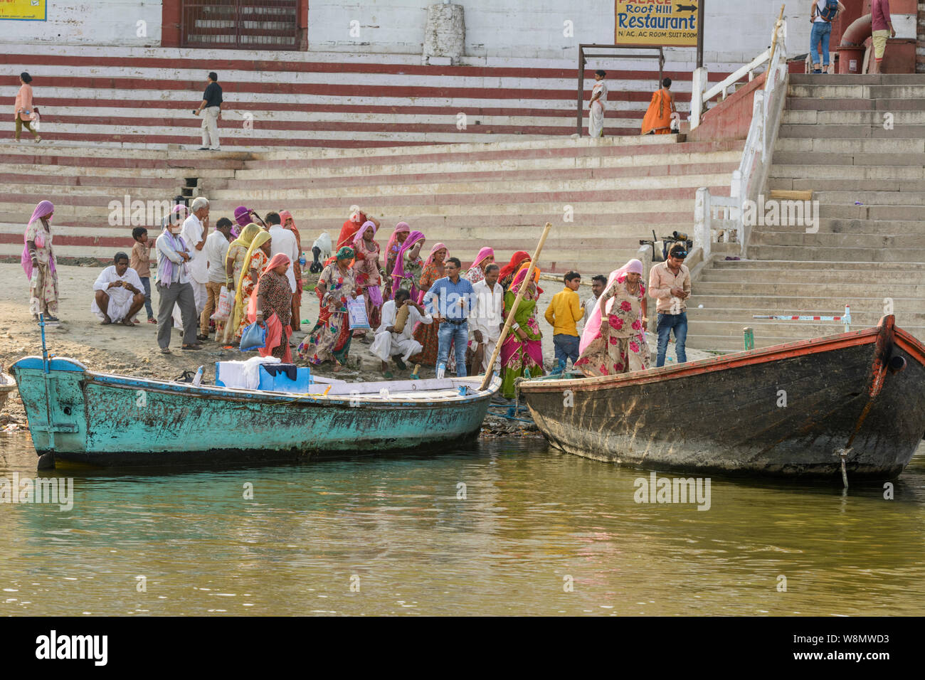 Indian pilgrims prepare for a boat ride on the River Ganges in Varanasi ...