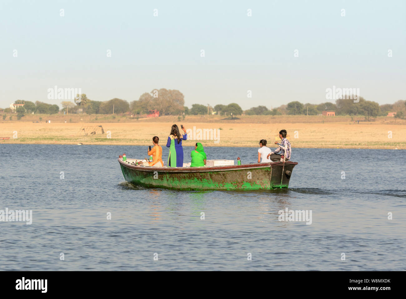 Indian tourists enjoy a boat ride on the River Ganges in Varanasi ...