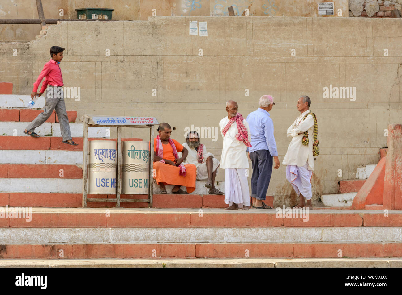 Indian men on the painted steps of a ghat on the River Ganges in ...