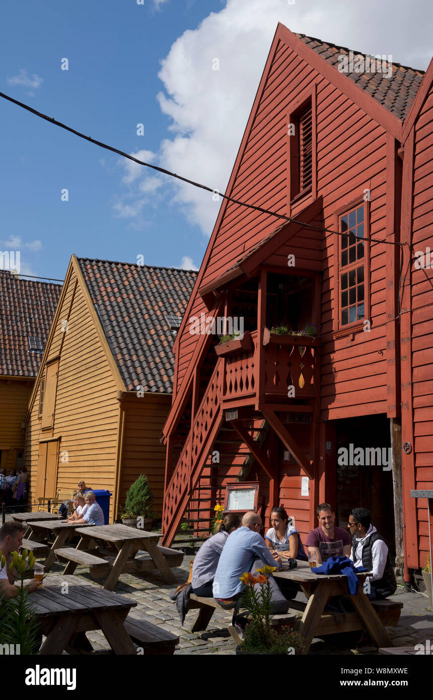 Tourists sit in the sun in outdoor bars and cafes in the old wharf and ...