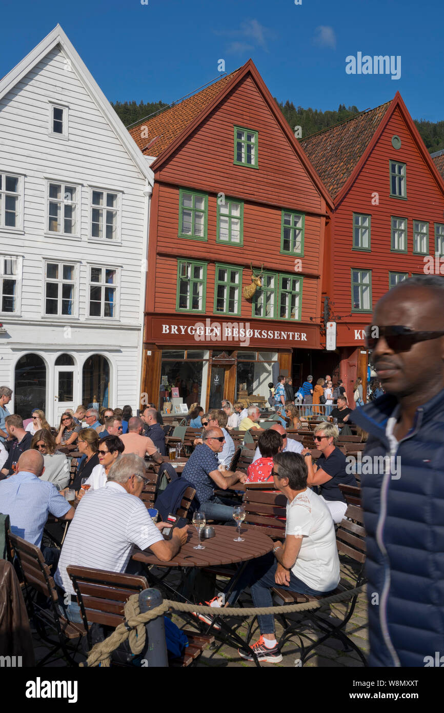 Tourists sit in the sun in outdoor bars and cafes in the old wharf and ...