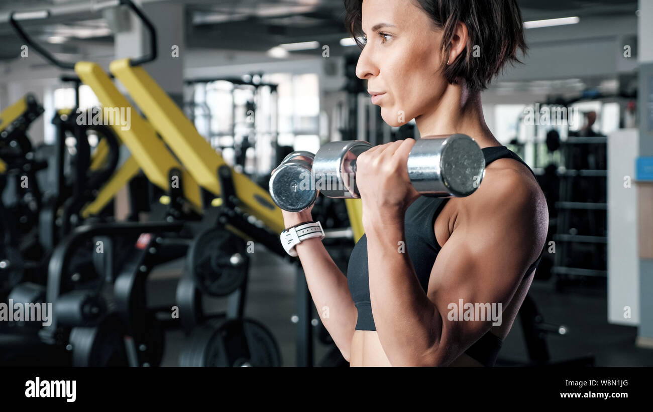 Portrait of athletic mature woman is making set of reps exercise for ...