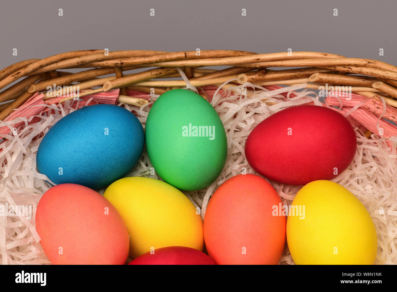 Top view of Easter eggs in basket on grey background. Horizontal ...