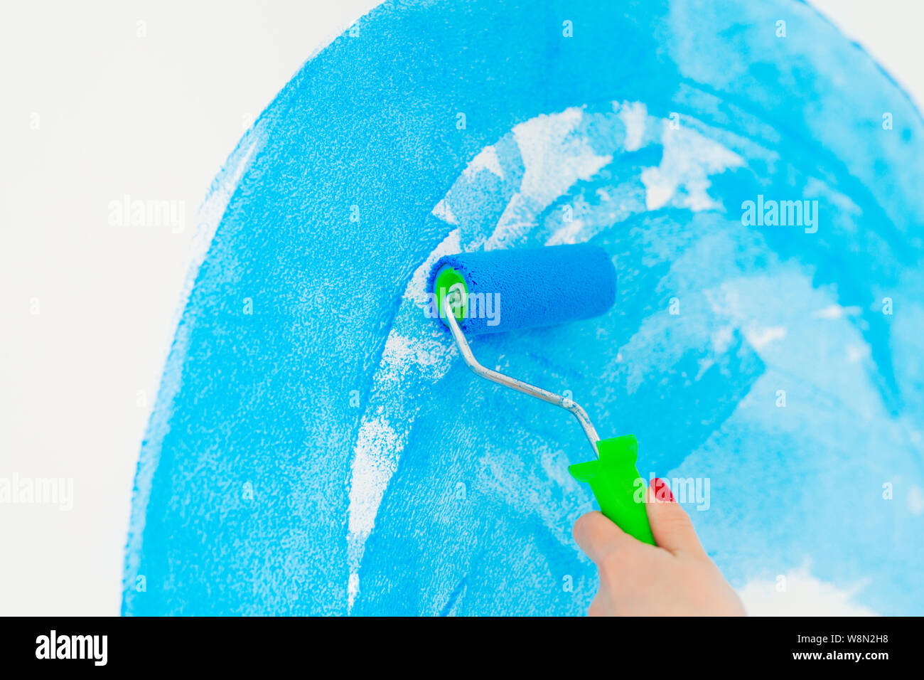 blue color painting wall with roller in hand Stock Photo - Alamy