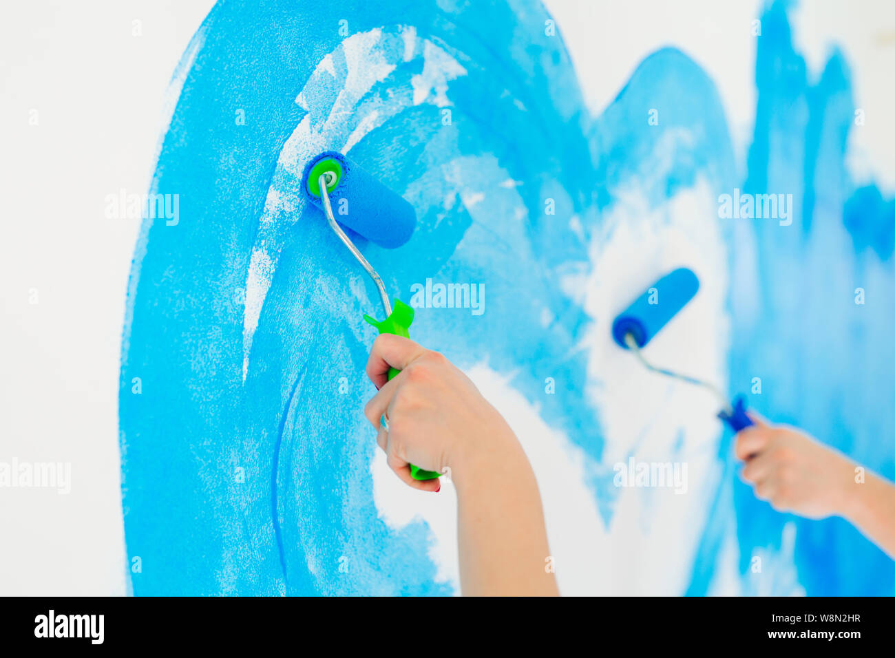 blue color painting wall with roller in hand Stock Photo - Alamy