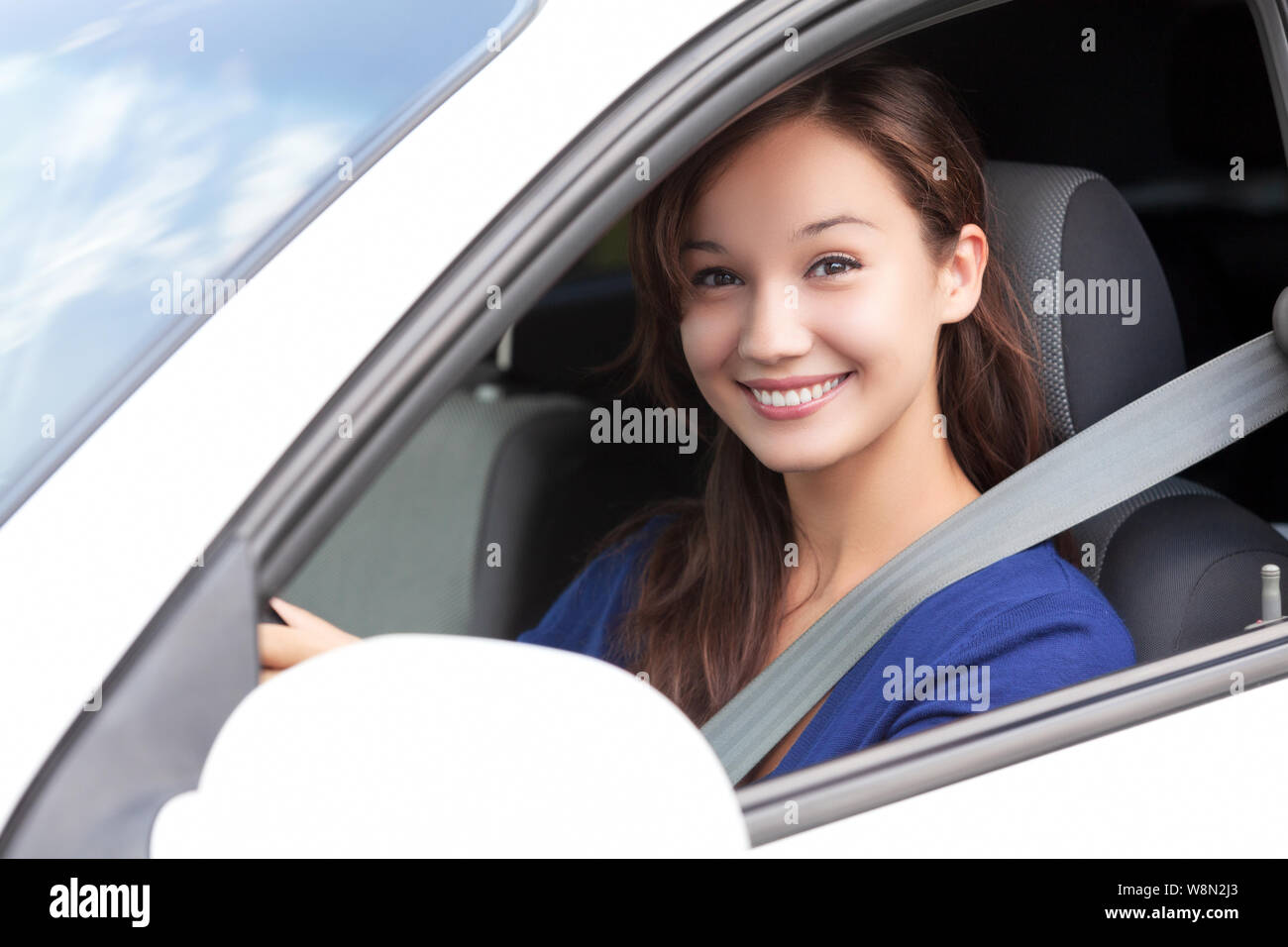 Happy owner of a new car. Pretty woman driver smiling to you from her ...