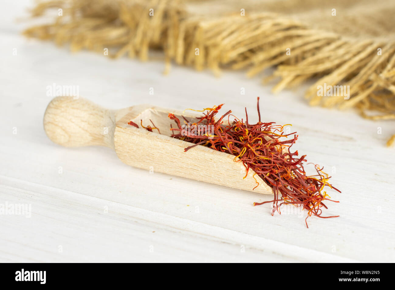 Lot of whole dry shaffron thread with wooden scoop and jute cloth on ...