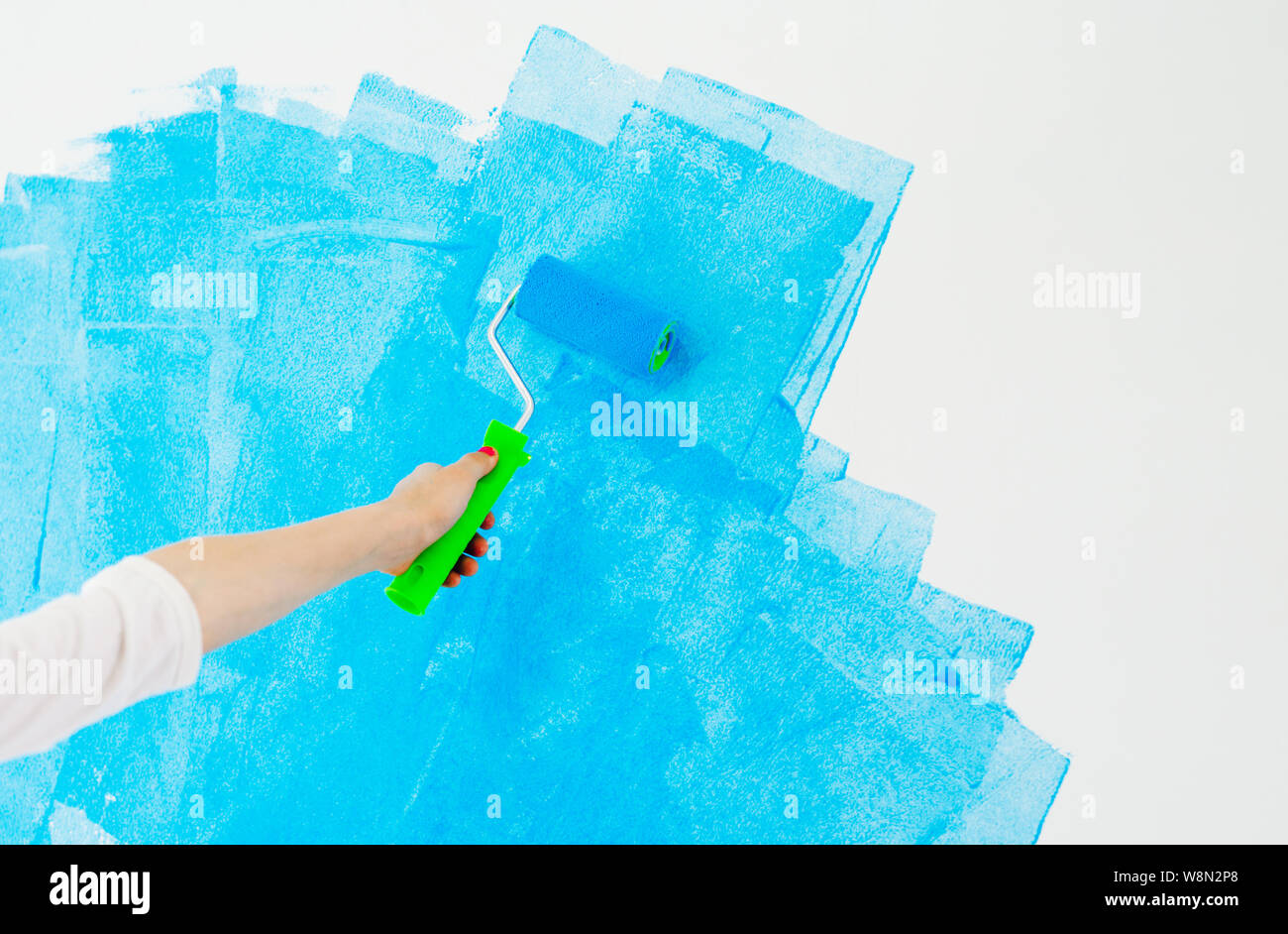 blue color painting wall with roller in hand Stock Photo - Alamy