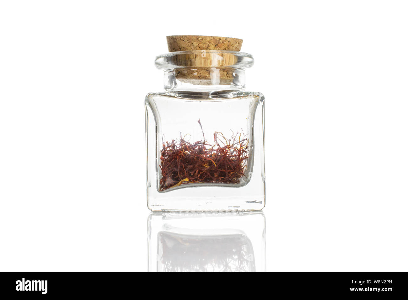 Lot of whole dry shaffron thread in glass bottle with cork cap isolated ...