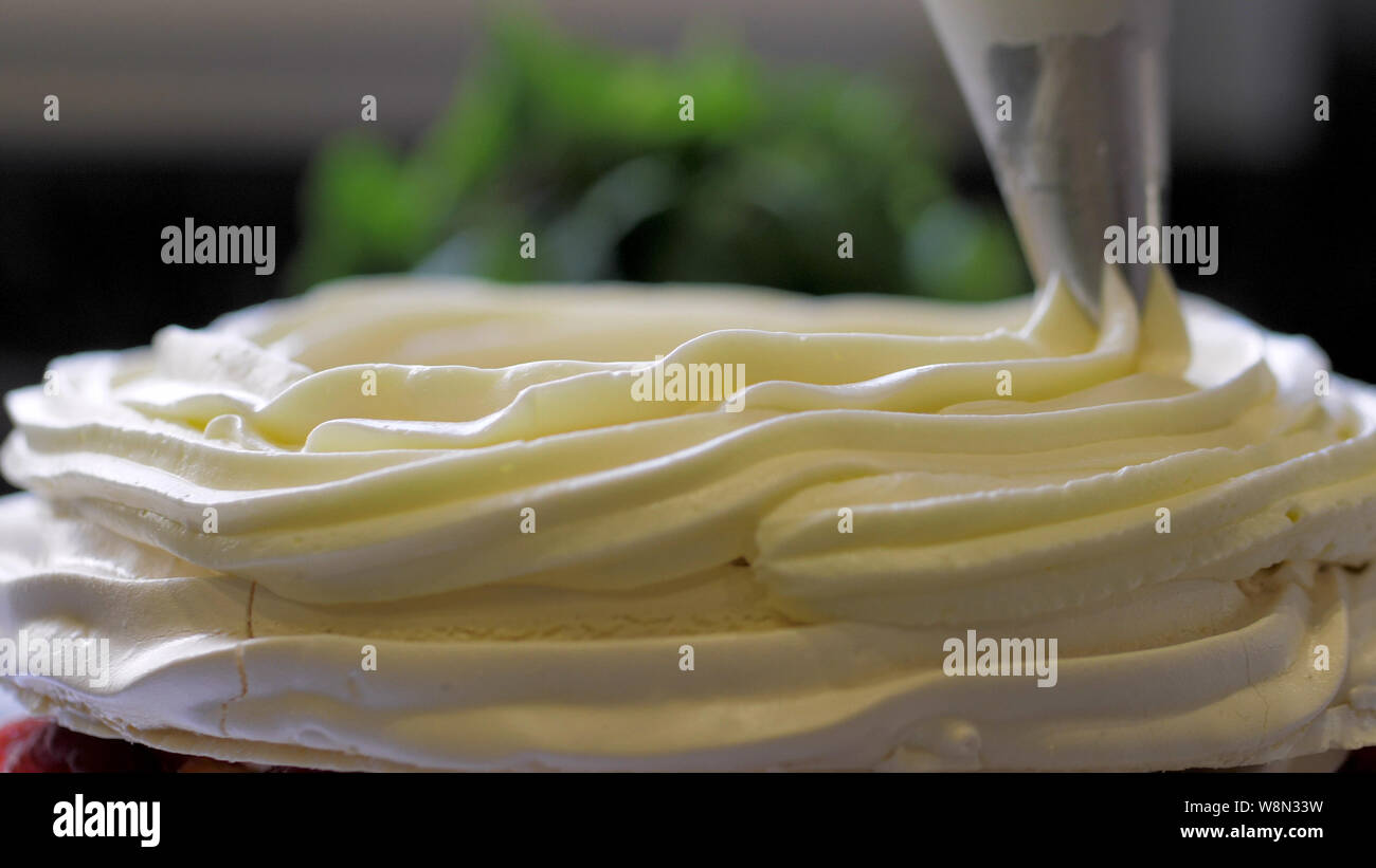 The process of making dessert Anna Pavlova with berries and cream Stock ...