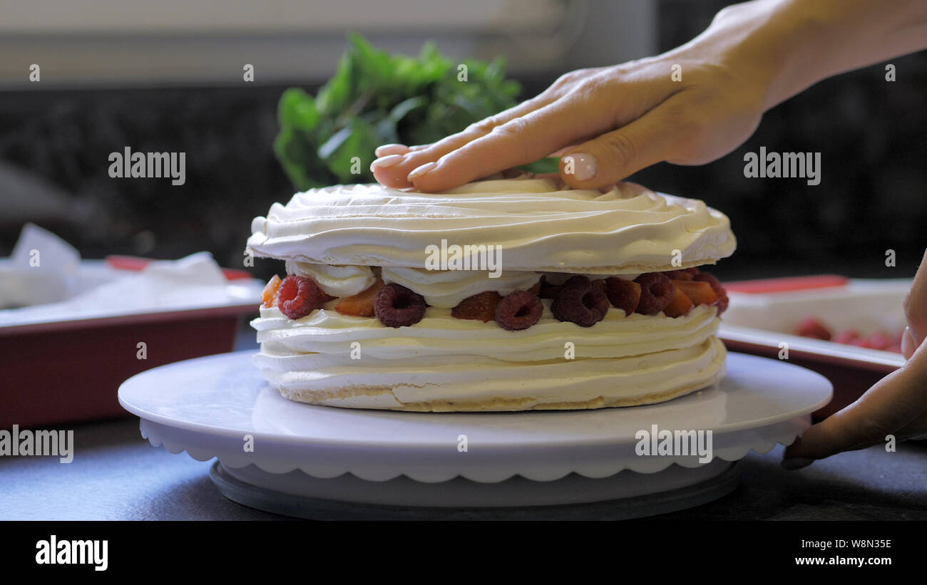 The process of making dessert Anna Pavlova with berries and cream Stock ...