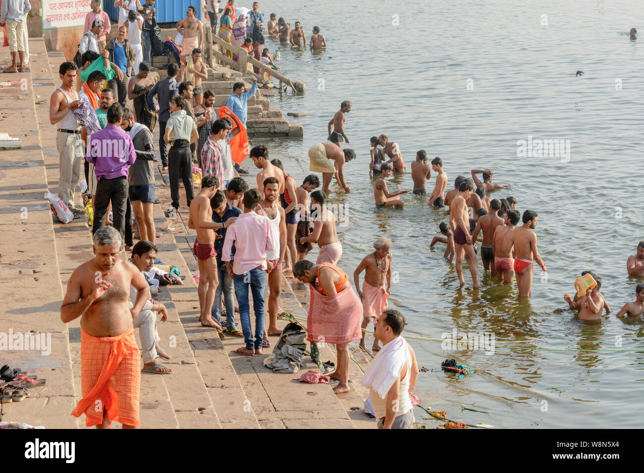 Indian pilgrims perform early morning bathing rituals in the River ...