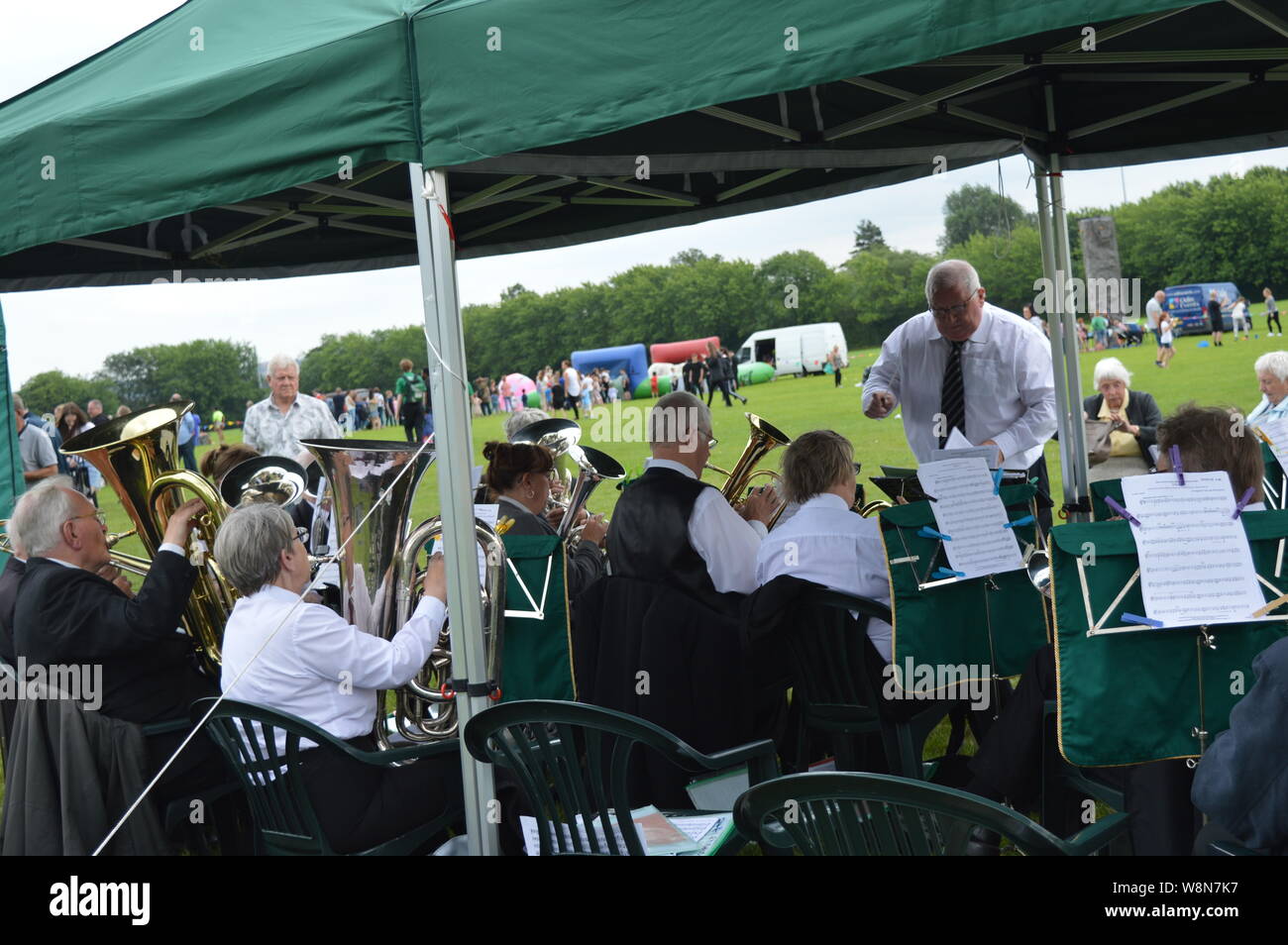 elderly playing instrument in a group lead by a retired old orchestra ...