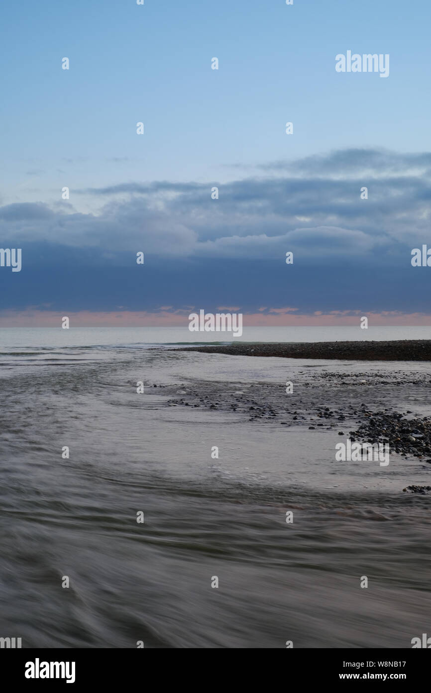 Outflow from the Cuckmere river estuary on a cool blue evening 1 Stock ...