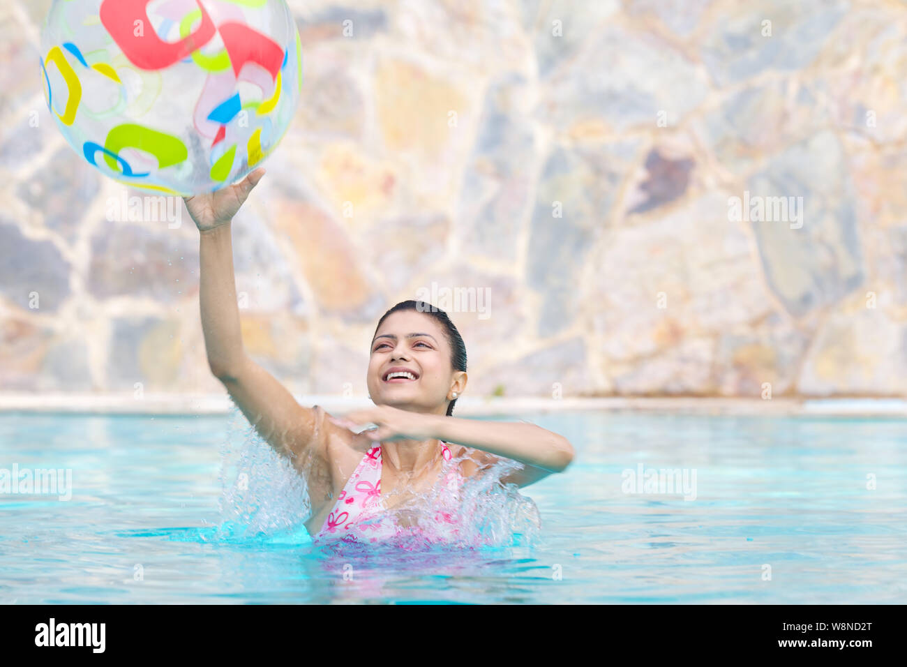 Young woman playing with a ball in a swimming pool Stock Photo - Alamy