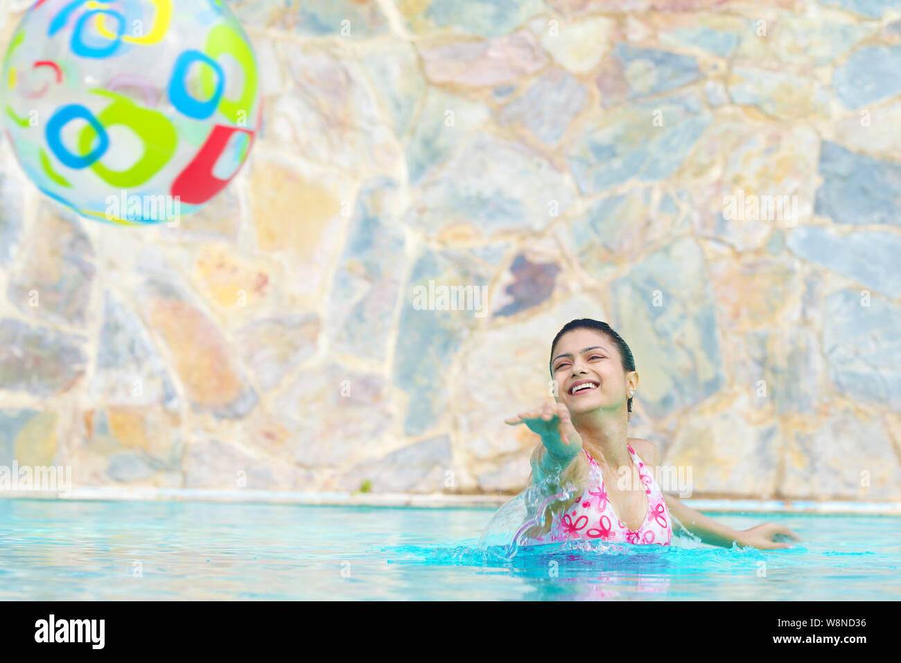Young woman playing with a ball in a swimming pool Stock Photo - Alamy