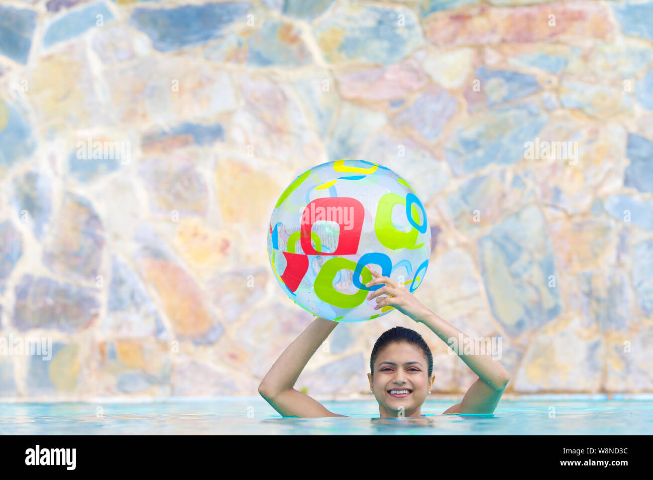 Young woman playing with a ball in a swimming pool Stock Photo - Alamy