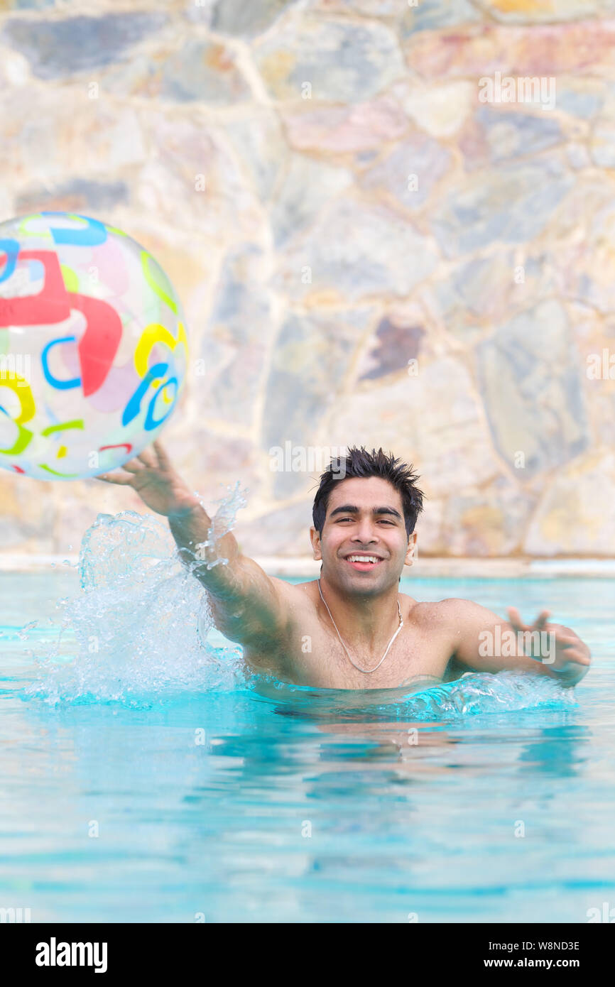 Young man playing with a ball in a swimming pool Stock Photo - Alamy