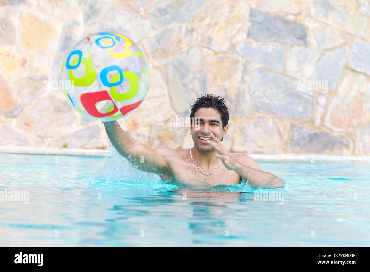 Young man playing with a ball in a swimming pool Stock Photo - Alamy