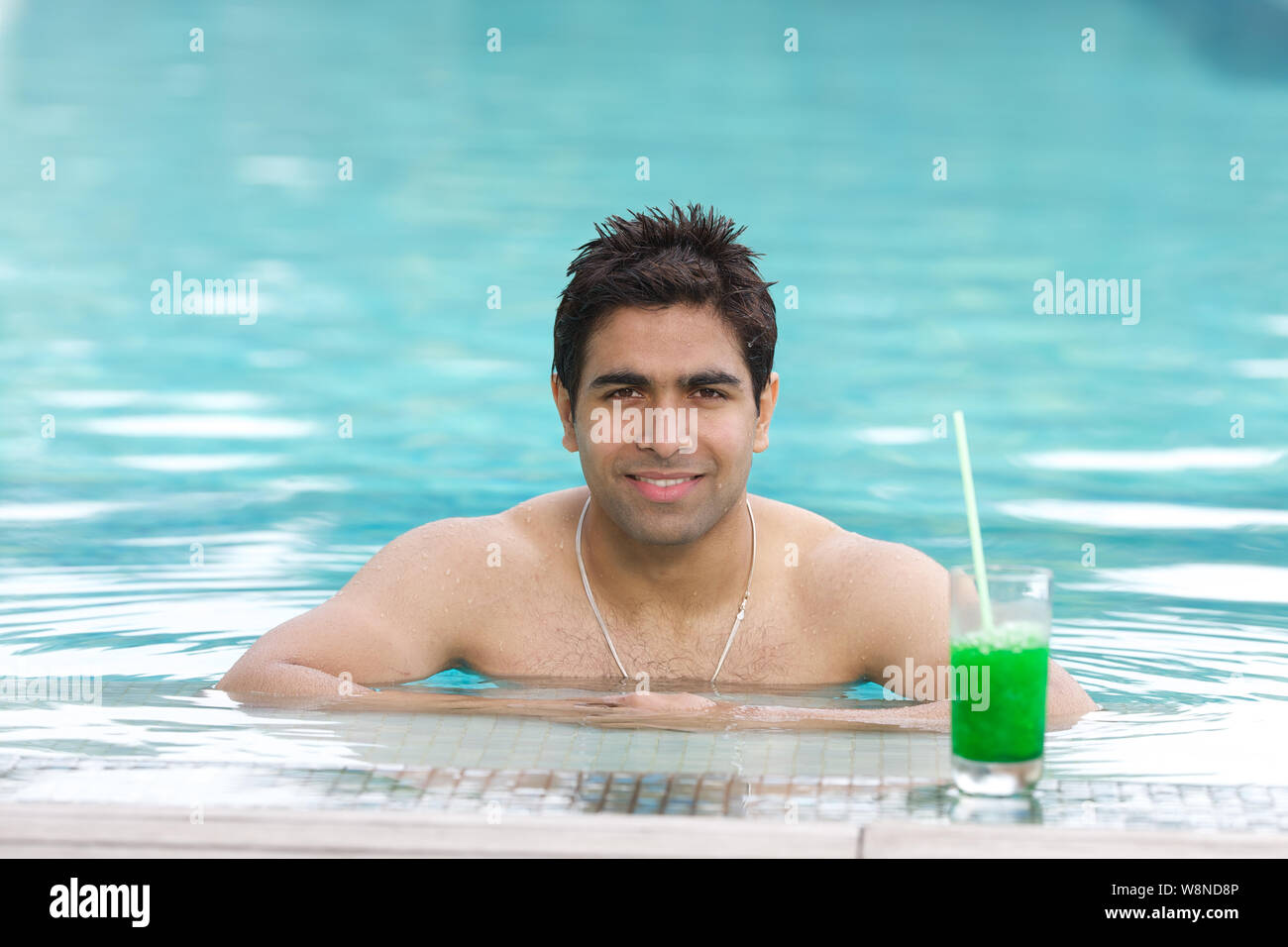 Young man enjoying in a swimming pool with drinks Stock Photo - Alamy