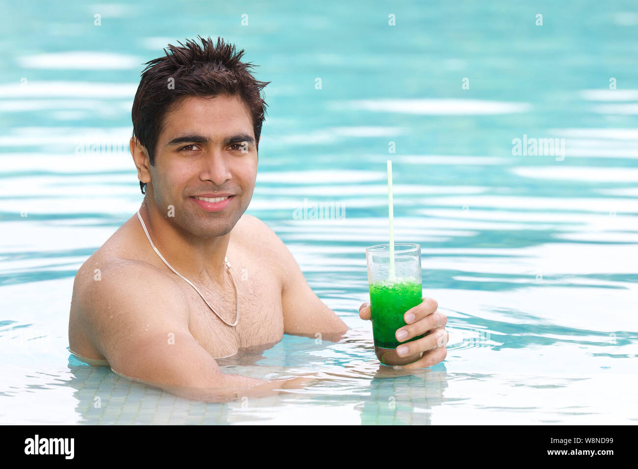 Young man enjoying in a swimming pool with drinks Stock Photo - Alamy