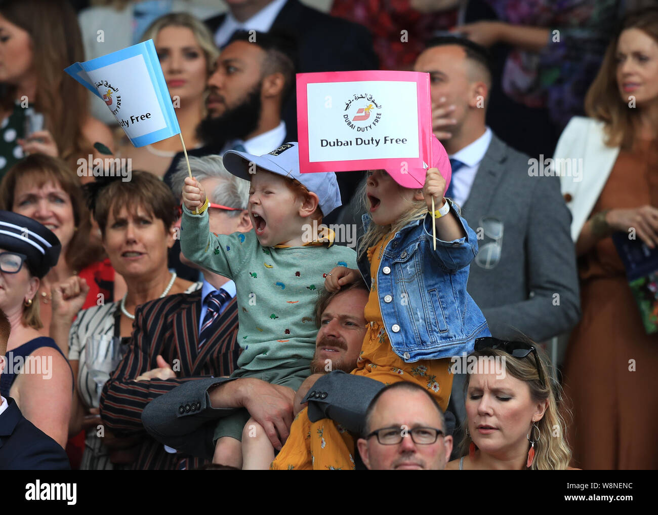 A Racegoer reacts as he carries two children on his shoulders at Ascot ...