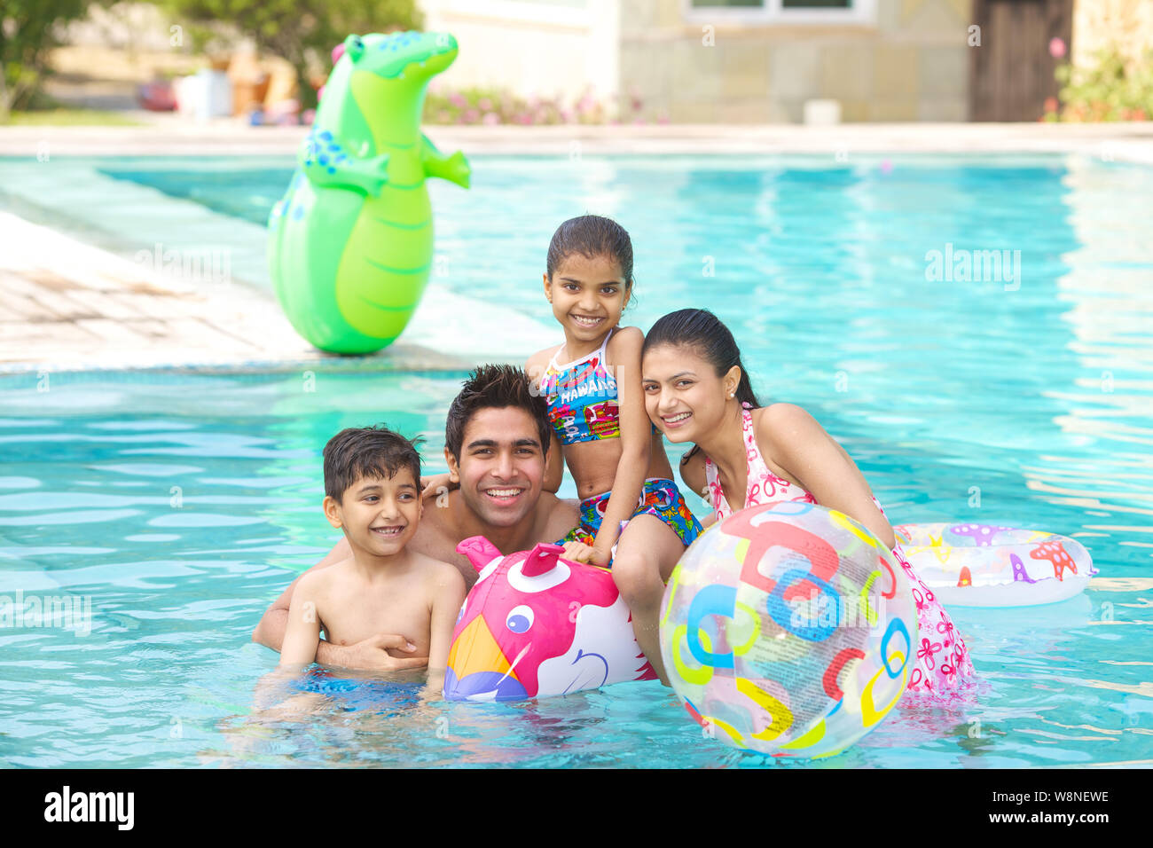 Family playing in a swimming pool Stock Photo - Alamy