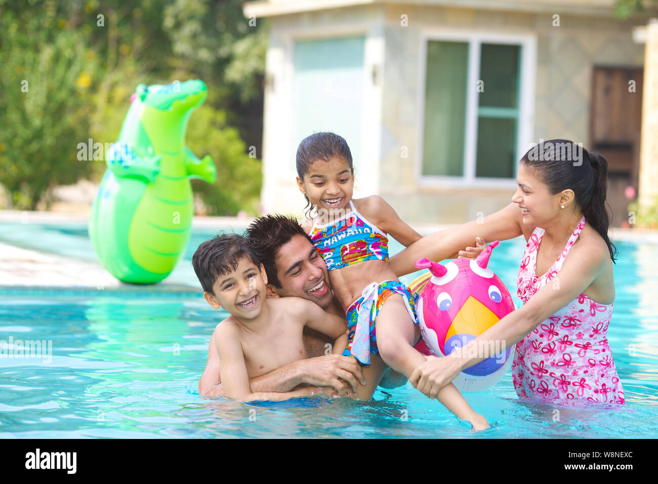 Family playing in a swimming pool Stock Photo - Alamy