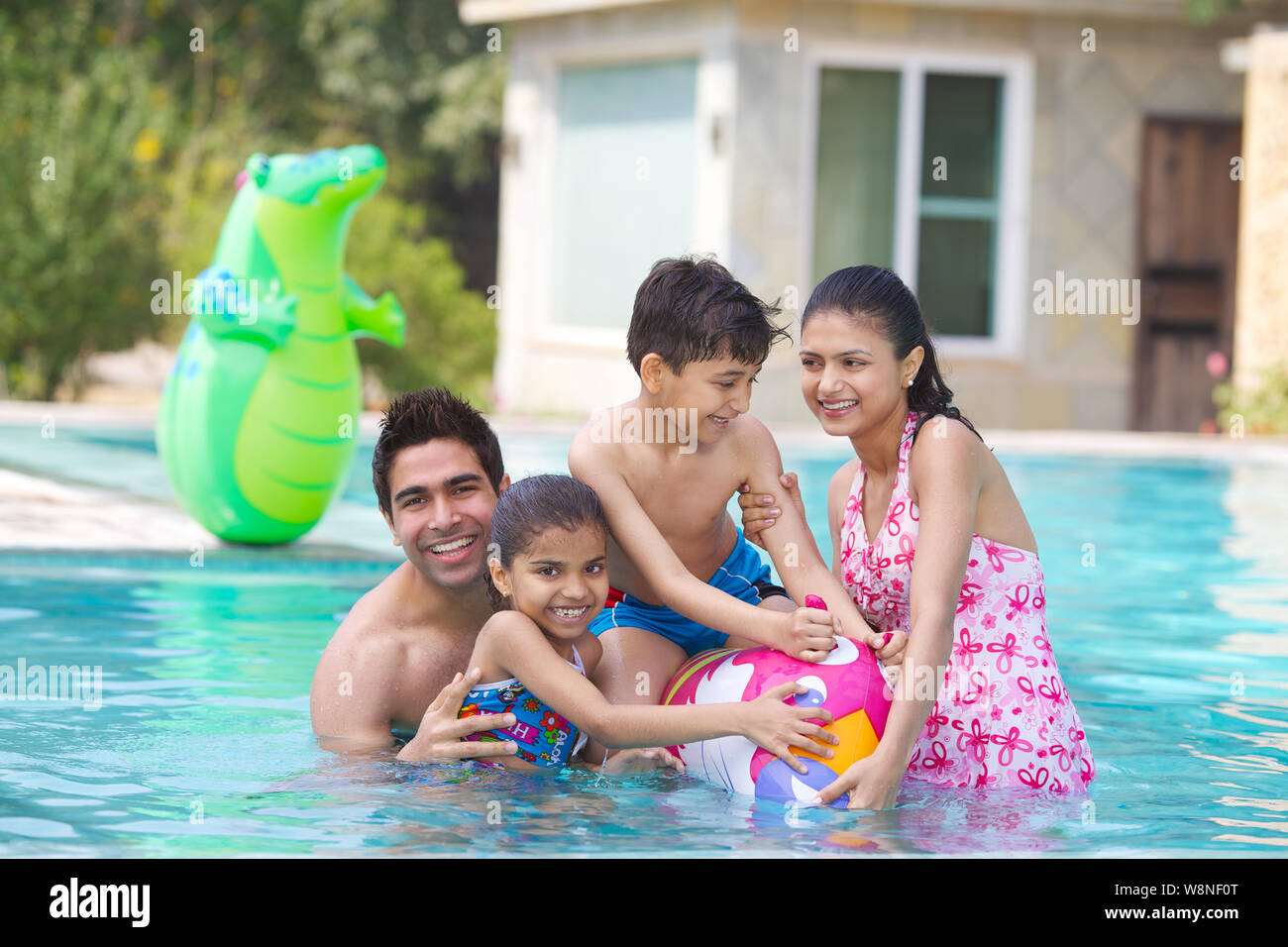 Family playing in a swimming pool Stock Photo - Alamy