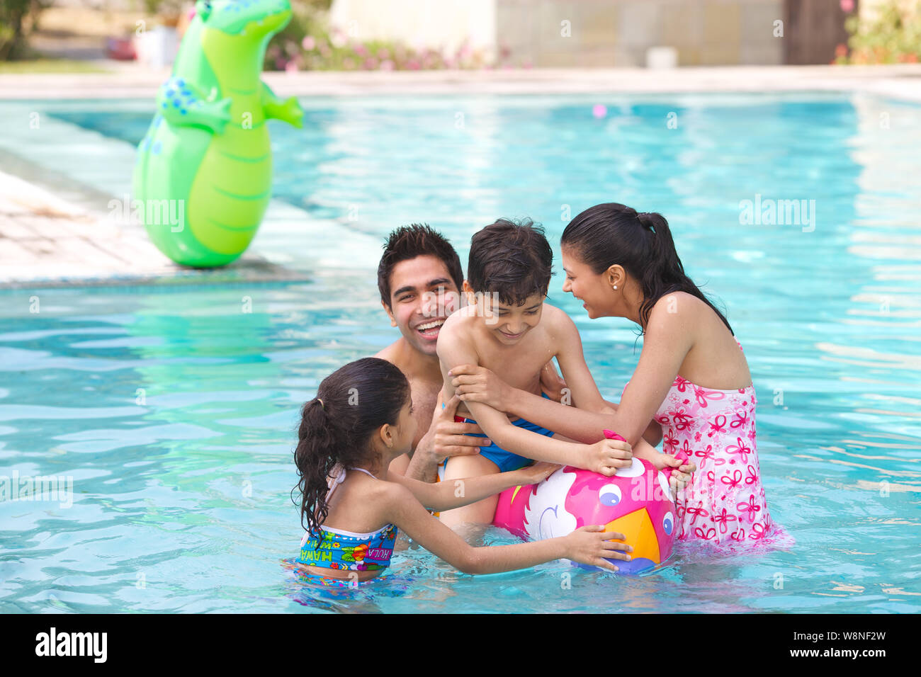 Family playing in a swimming pool Stock Photo - Alamy