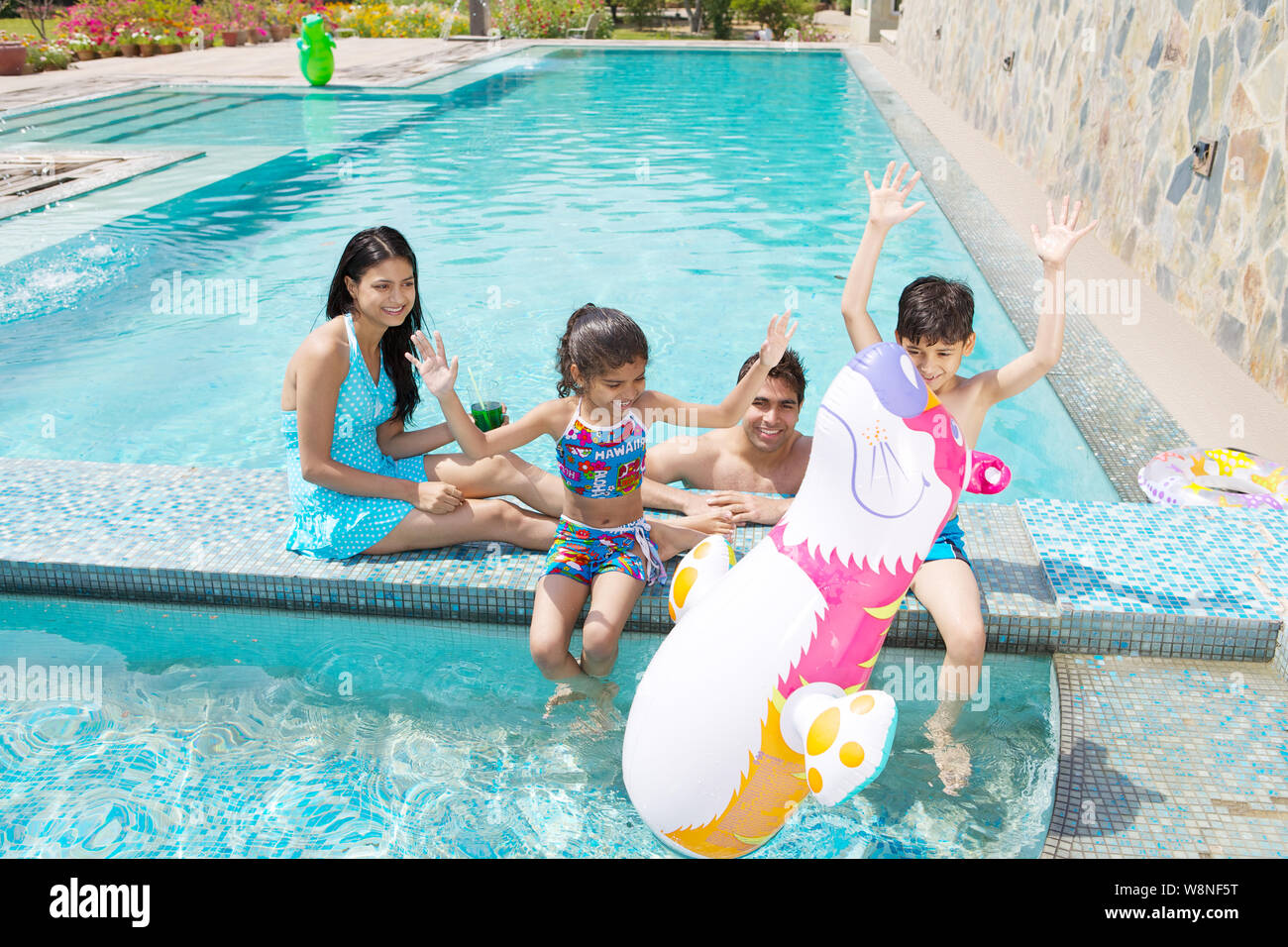 Family playing in a swimming pool Stock Photo - Alamy